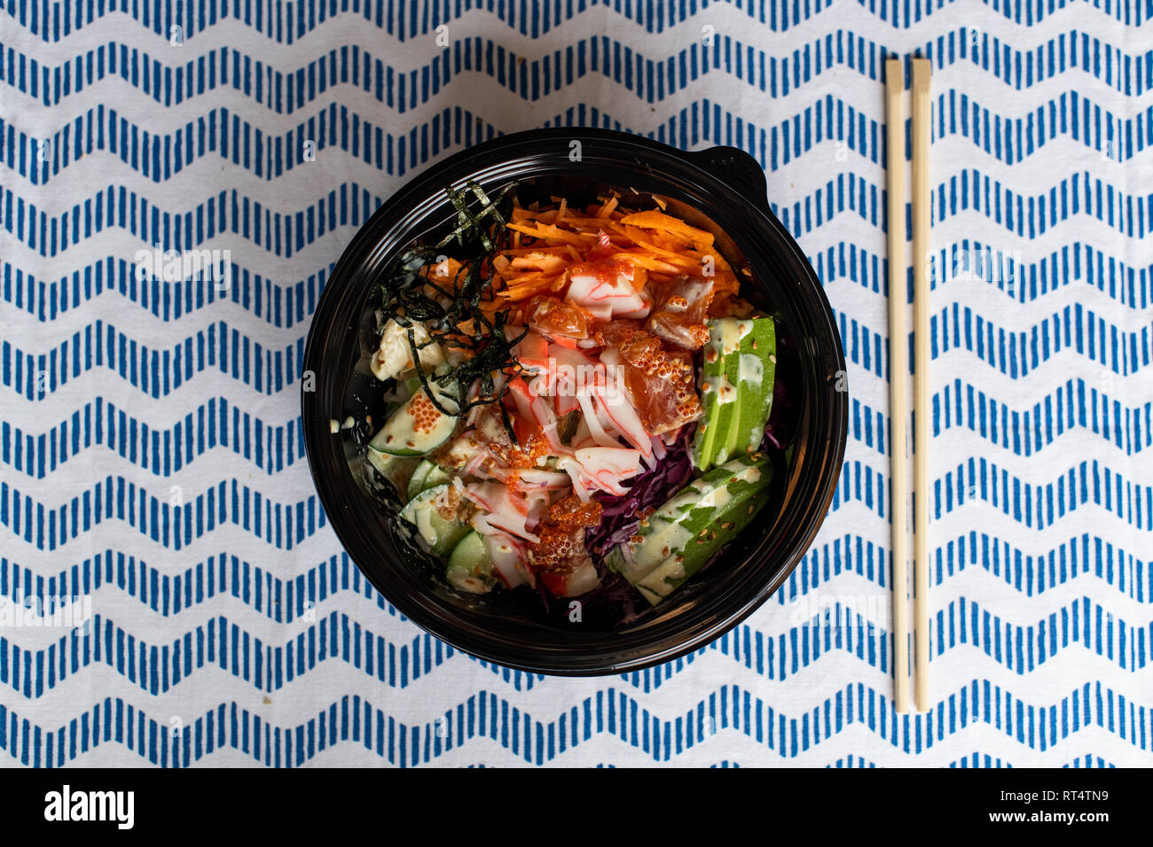 hawaii poke bowl with salmon, rice, surimi, avocado, tobiko, carrot and ...