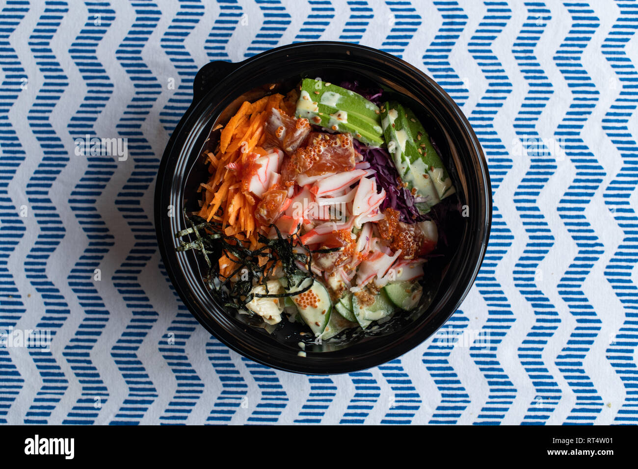 hawaii poke bowl with salmon, rice, surimi, avocado, tobiko, carrot and ...
