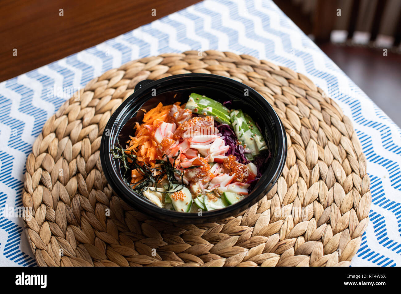hawaii poke bowl with salmon, rice, surimi, avocado, tobiko, carrot and ...