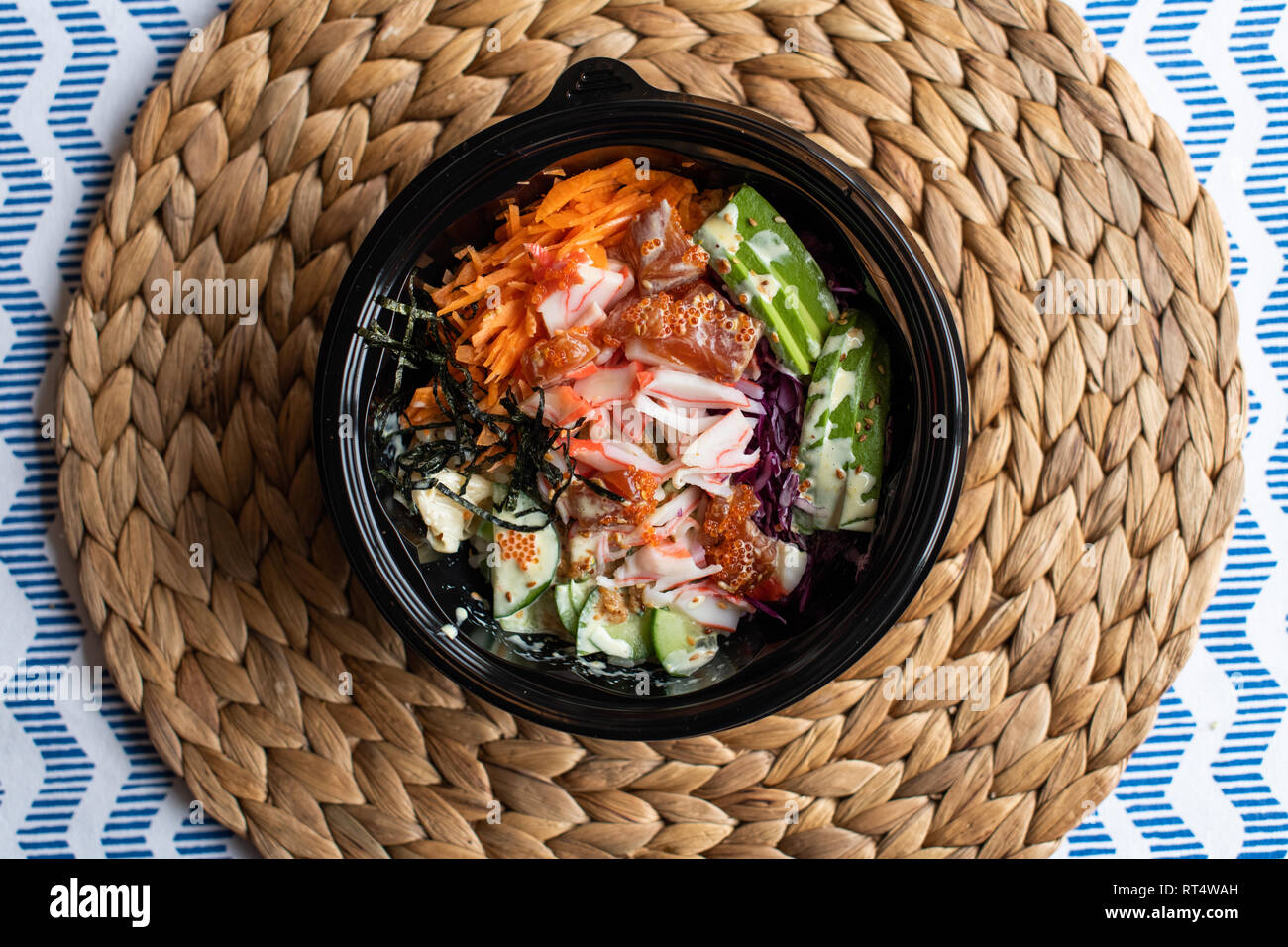 hawaii poke bowl with salmon, rice, surimi, avocado, tobiko, carrot and ...