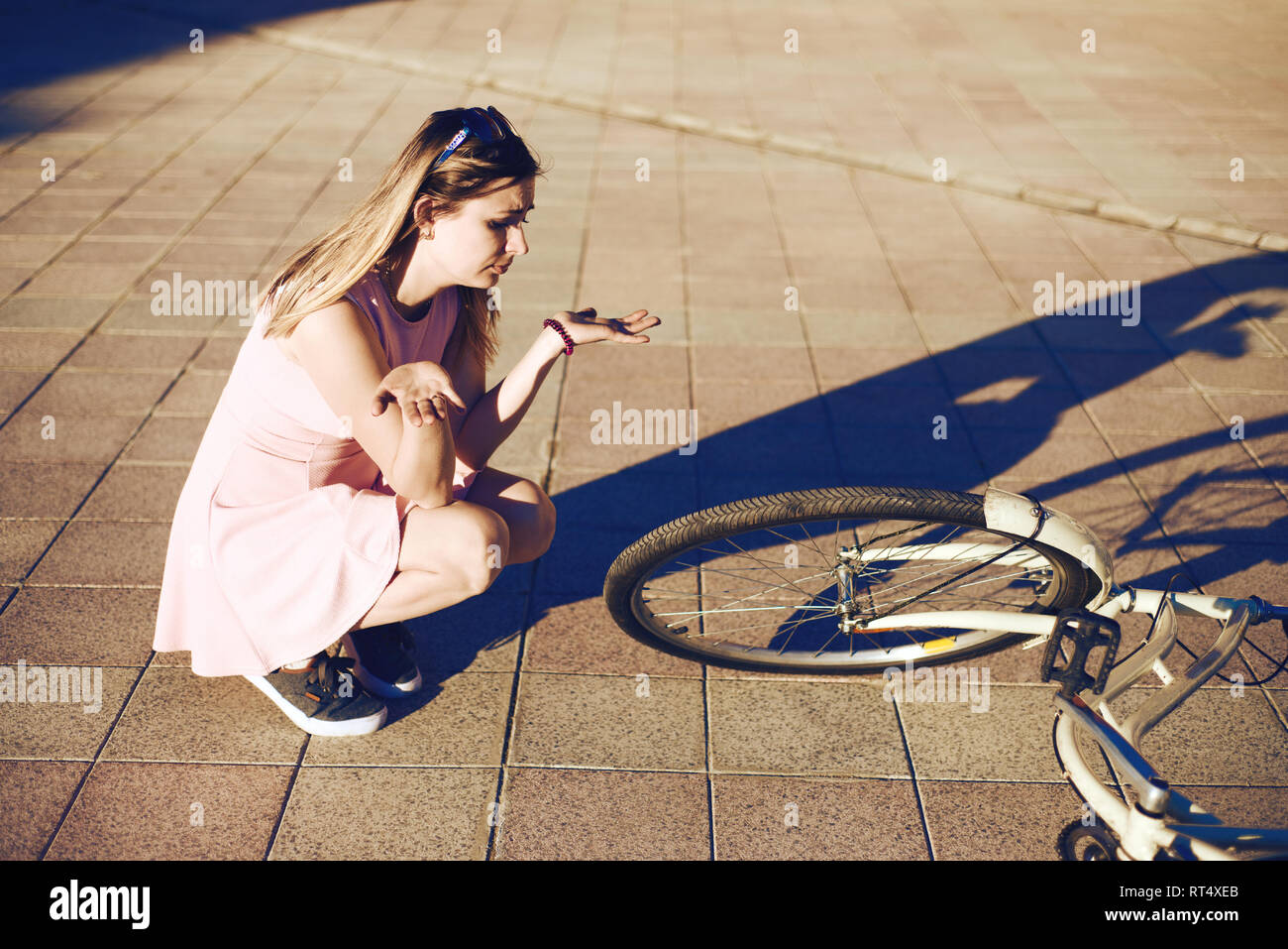 girl dropped and broke the bicycle. emotion is upset and does not know ...