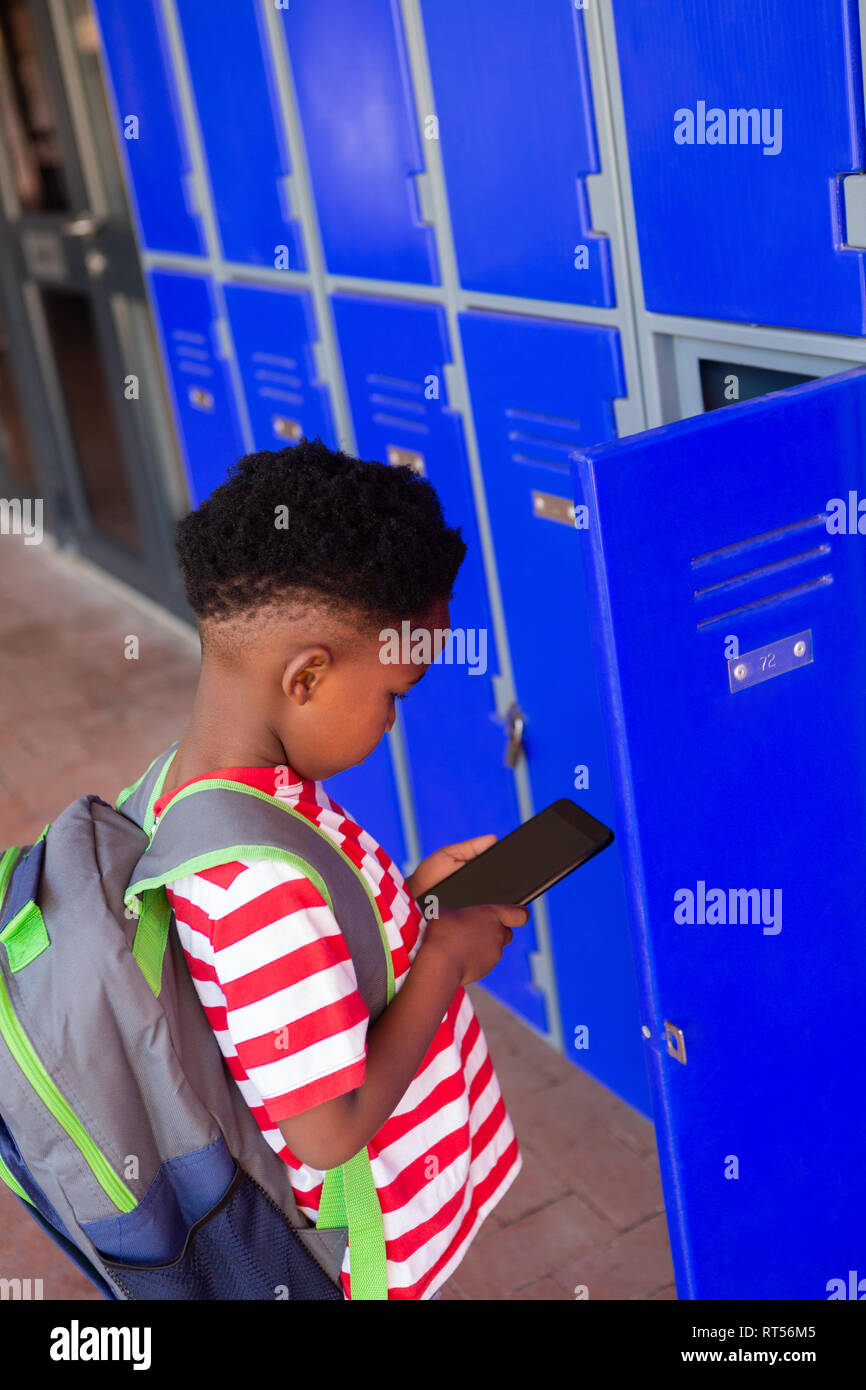 Schoolboy holding mobile phone in the locker room Stock Photo - Alamy