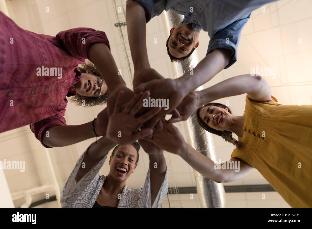 Business colleagues forming hand stack in office Stock Photo - Alamy
