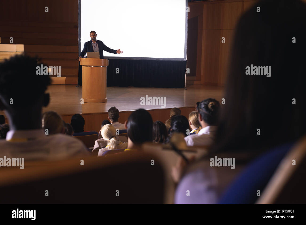 Businessman giving presentation on white projector in front of the ...