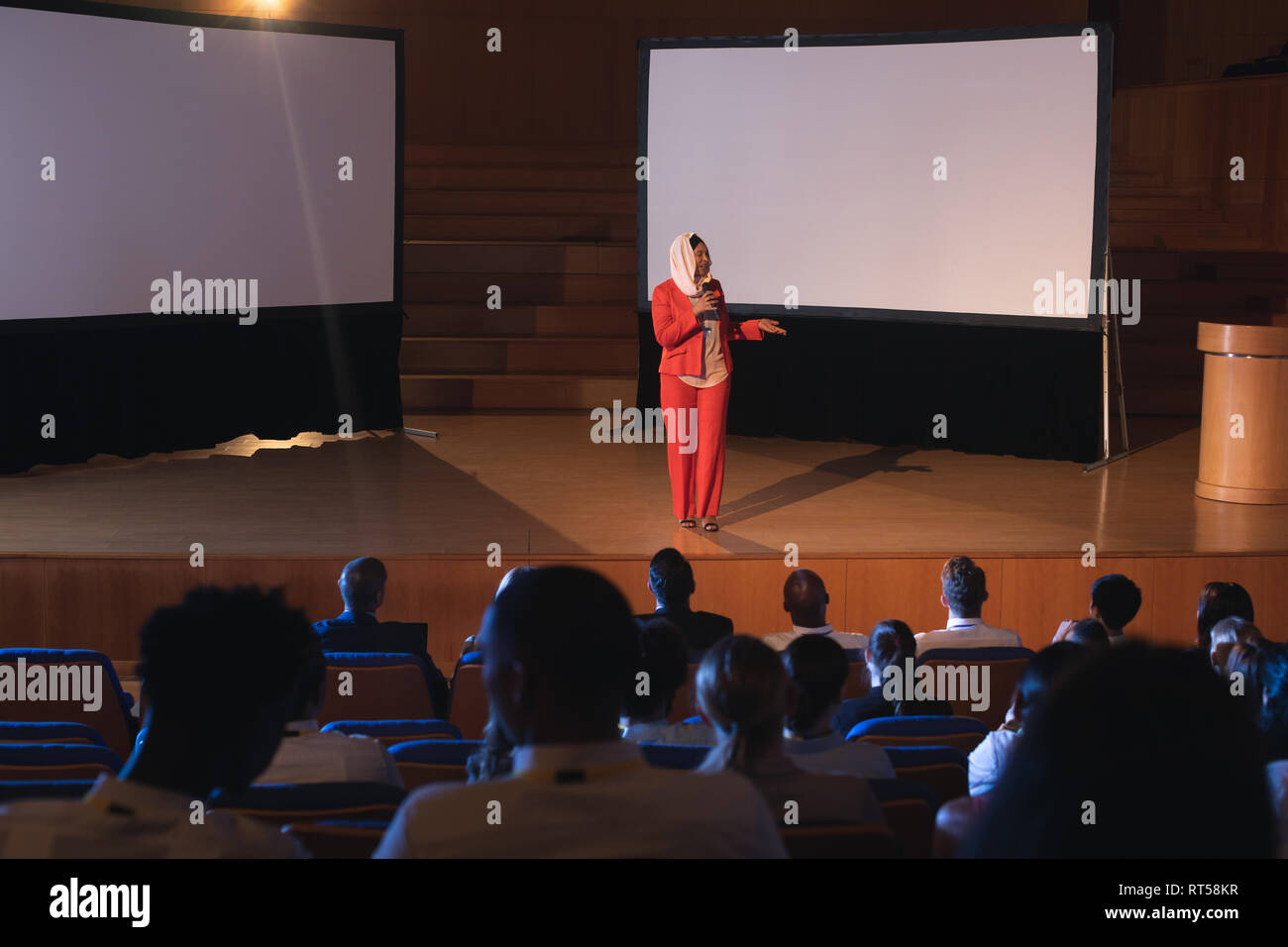 Businesswoman standing and giving presentation in auditorium Stock ...