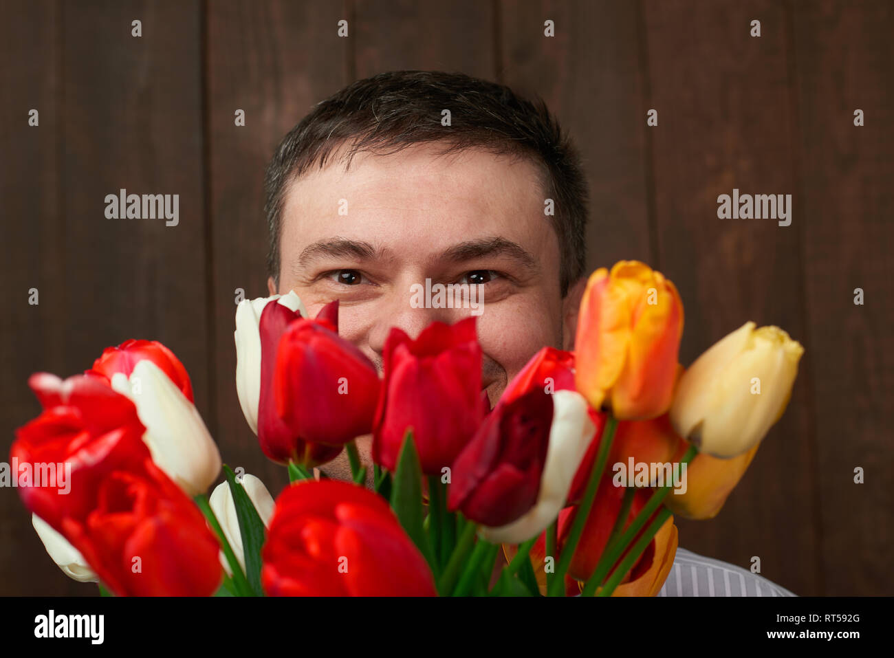 Man face is behind tulip flowers Stock Photo - Alamy