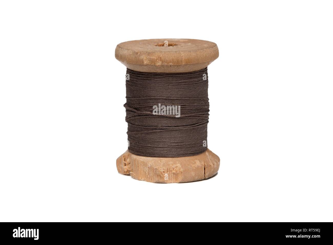 Wooden coil with sewing thread on a white background Stock Photo - Alamy