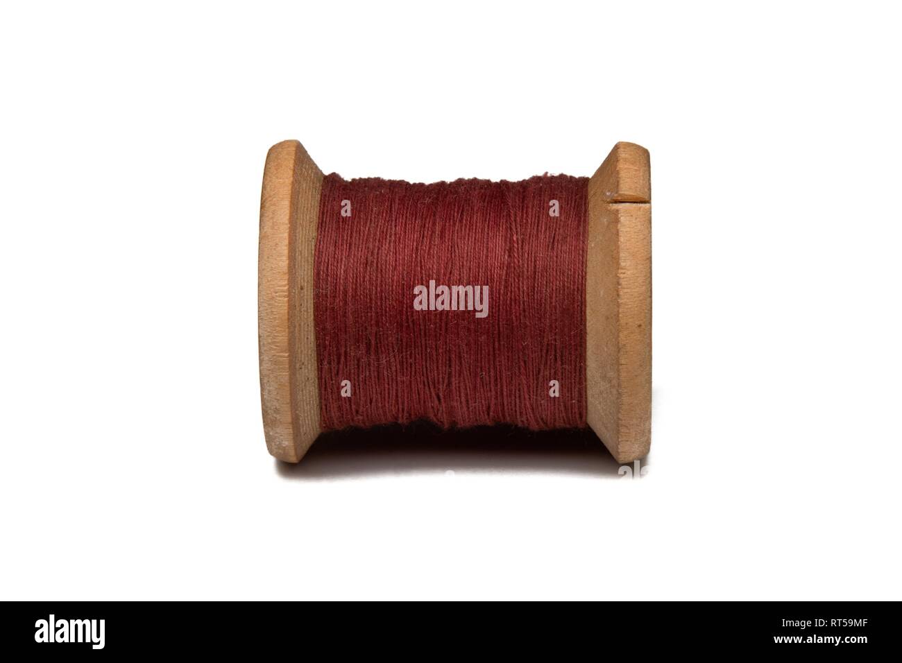Wooden coil with sewing thread on a white background Stock Photo - Alamy