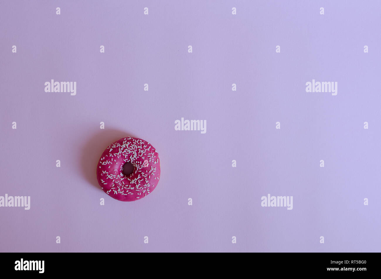Donuts with pink icing on pastel background with place for text ...