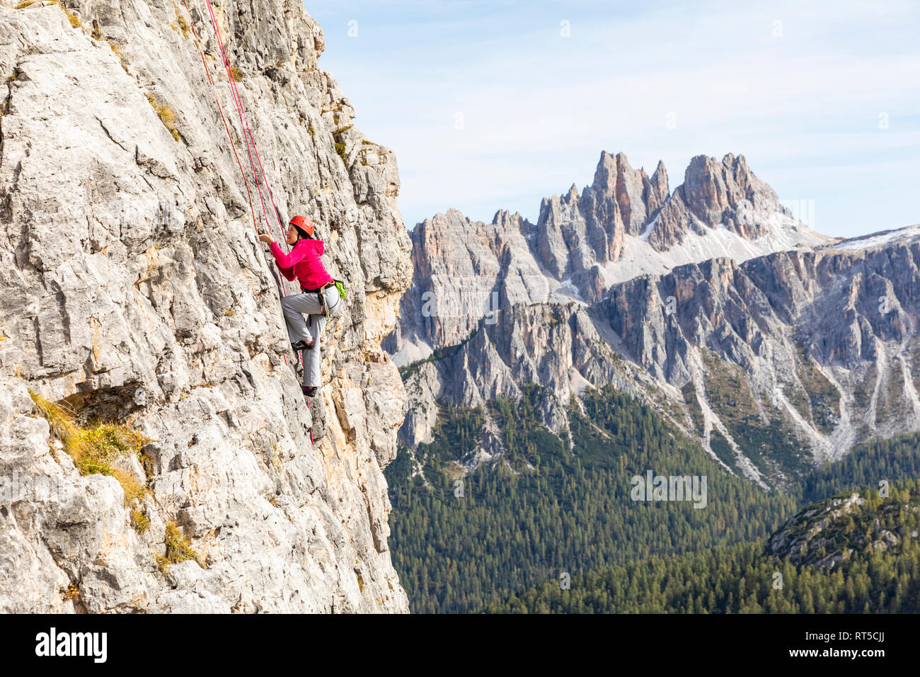 Italy, Cortina d'Ampezzo, woman climbing in the Dolomites mountains ...