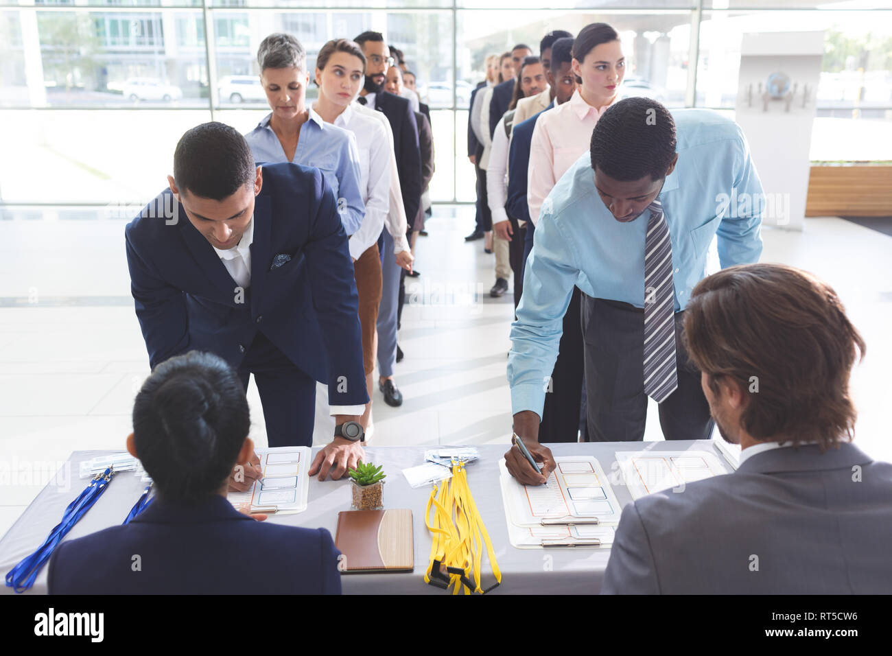 Business people checking in at conference registration table Stock ...