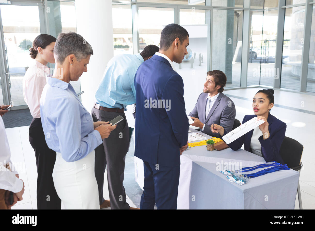 Business people checking in at conference registration table Stock ...