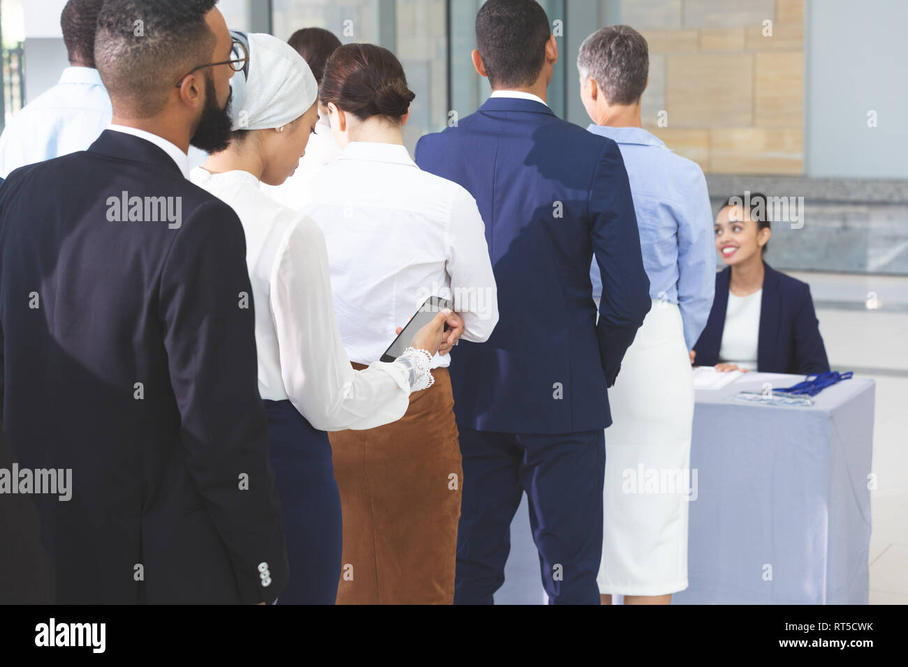 Business people checking in at conference registration table Stock ...