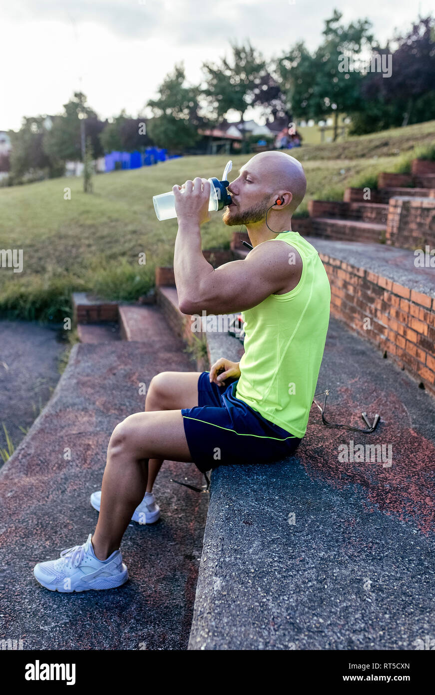 Muscular man having a break from exercising drinking water Stock Photo ...