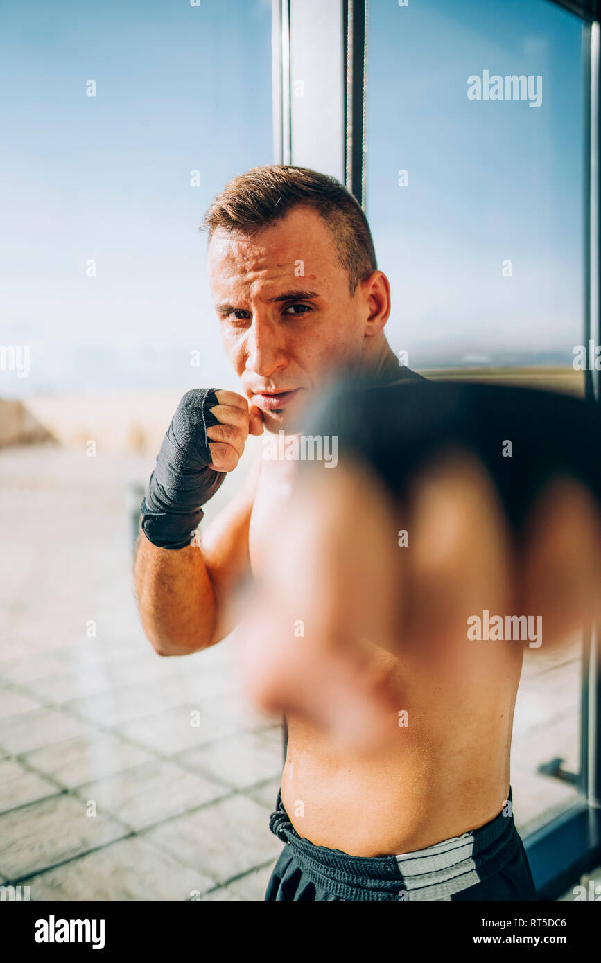 Portrait of boxer wearing bandages boxing at the window Stock Photo - Alamy