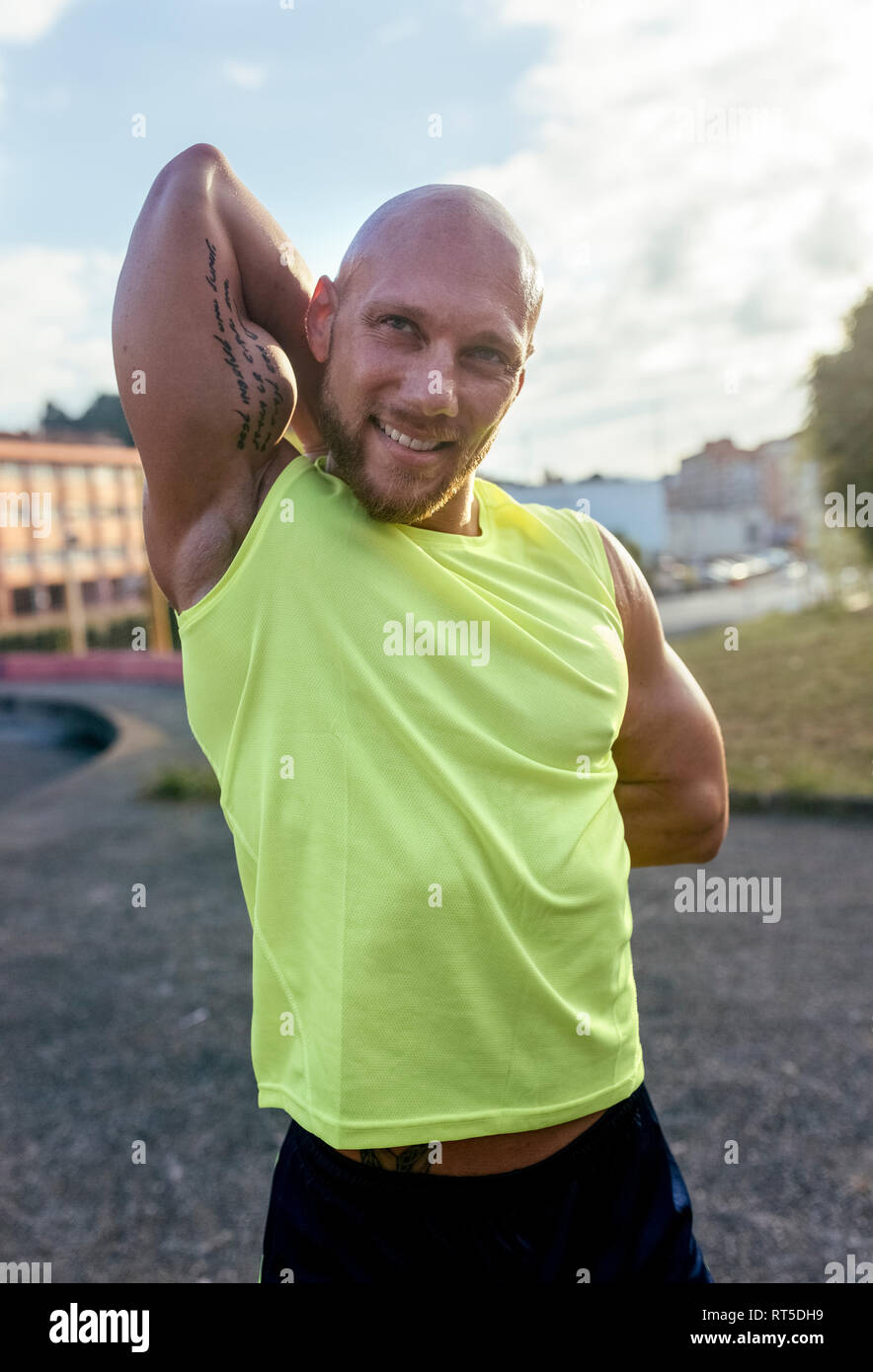 Smiling muscular man stretching outdoors Stock Photo - Alamy