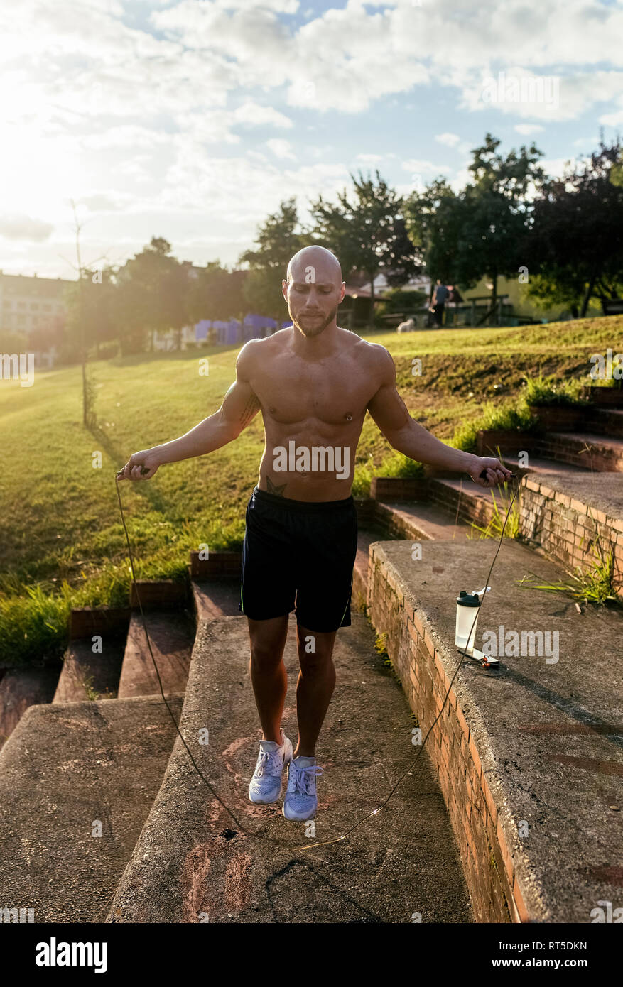 Barechested muscular man skipping rope outdoors Stock Photo - Alamy