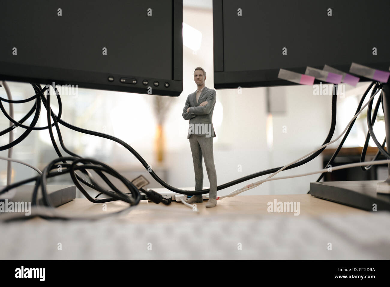 Businessman figurine standing under computer screens Stock Photo - Alamy