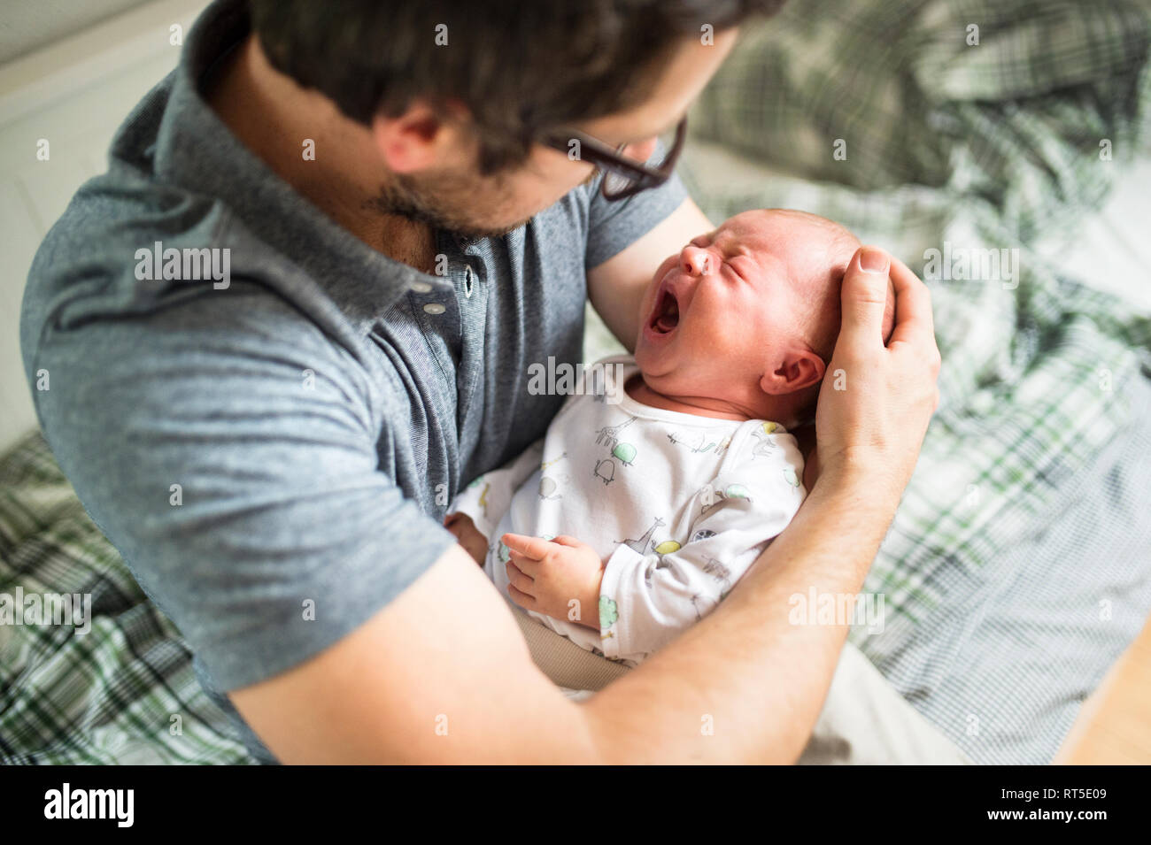 Father at home consoling his crying baby daughter Stock Photo - Alamy