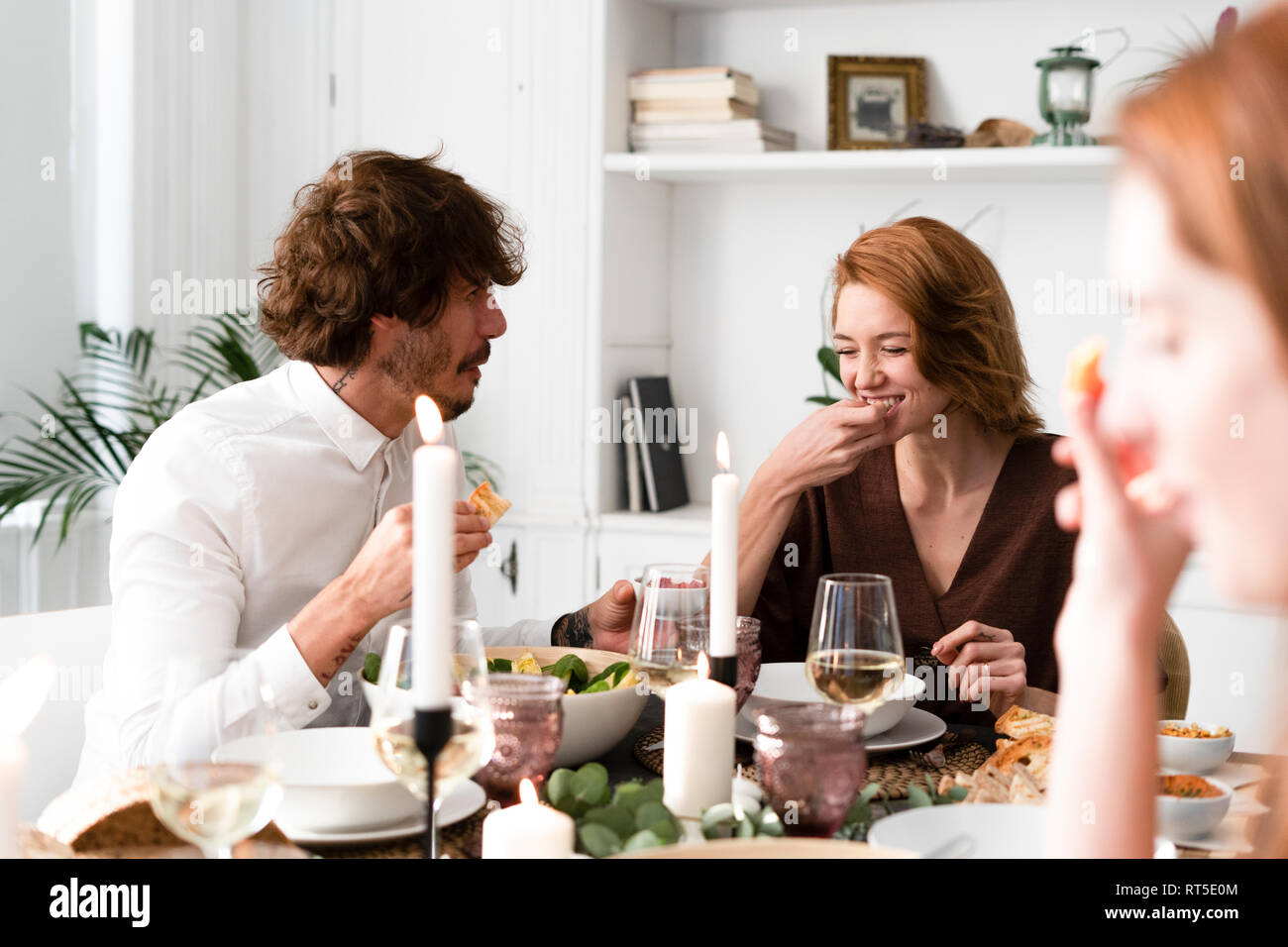 Friends having fun at a dinner party, enjoying eating together Stock ...