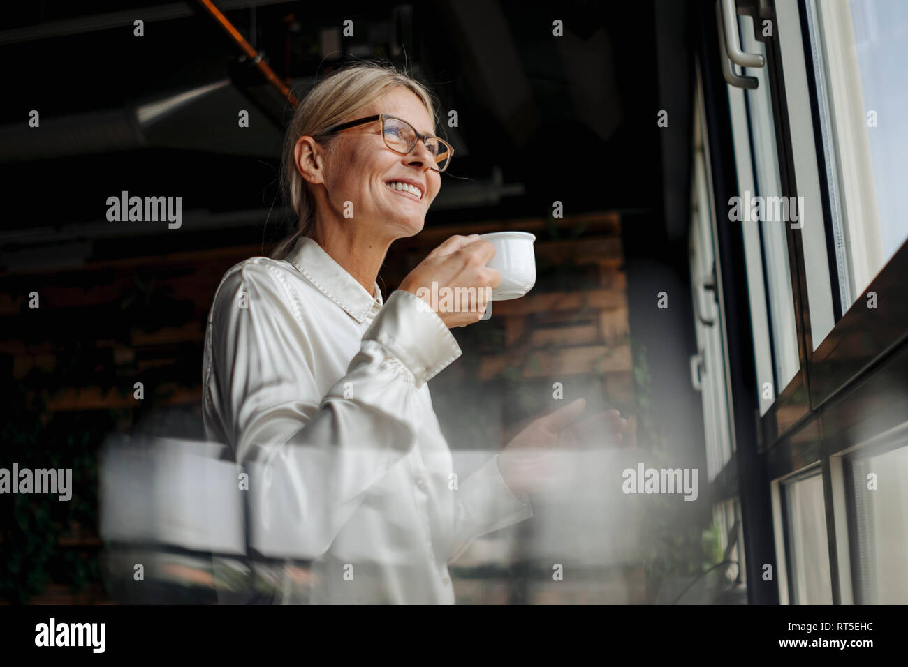 Portrait blond woman drinking coffee window hi-res stock photography ...