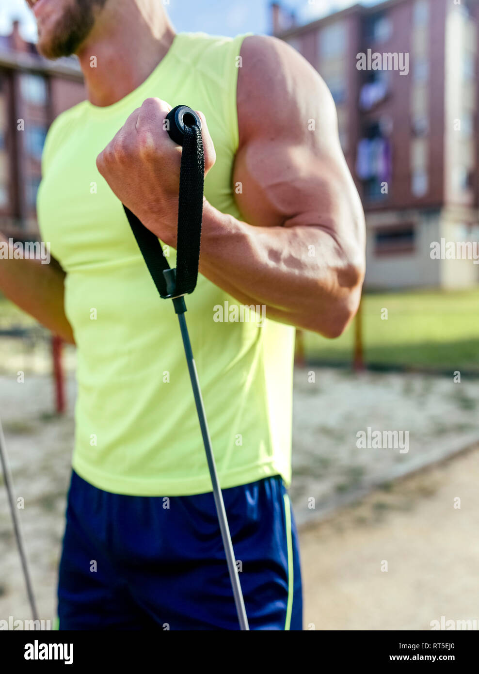 Close-up of muscular man exercising with expander outdoors Stock Photo ...