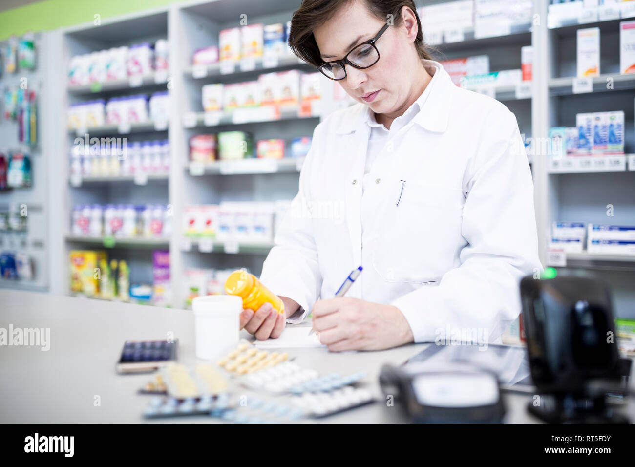 Pharmacist with medicine at counter in pharmacy Stock Photo - Alamy