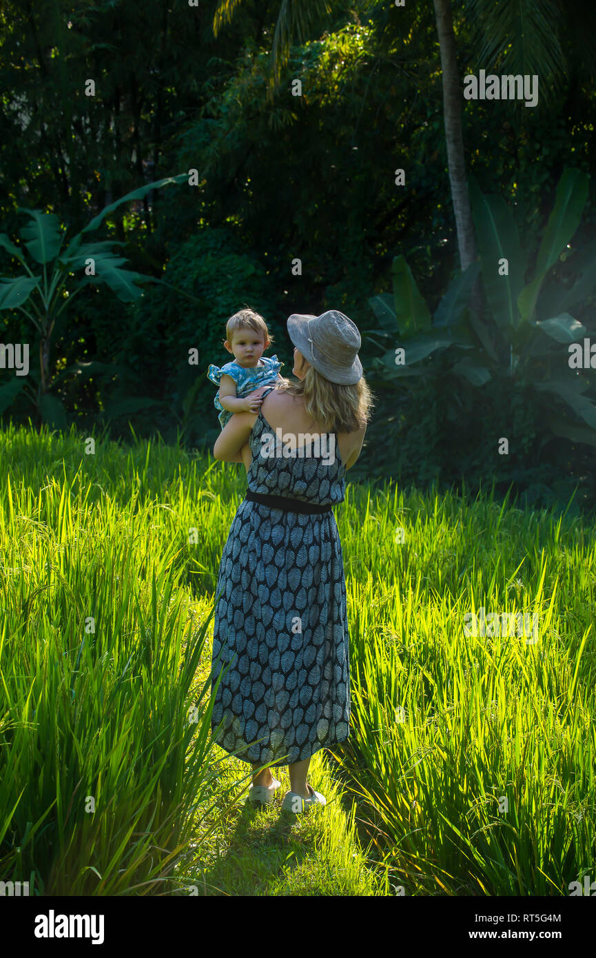 Indonesia, Bali, Ubud, Woman with her baby girl in the rice paddies ...
