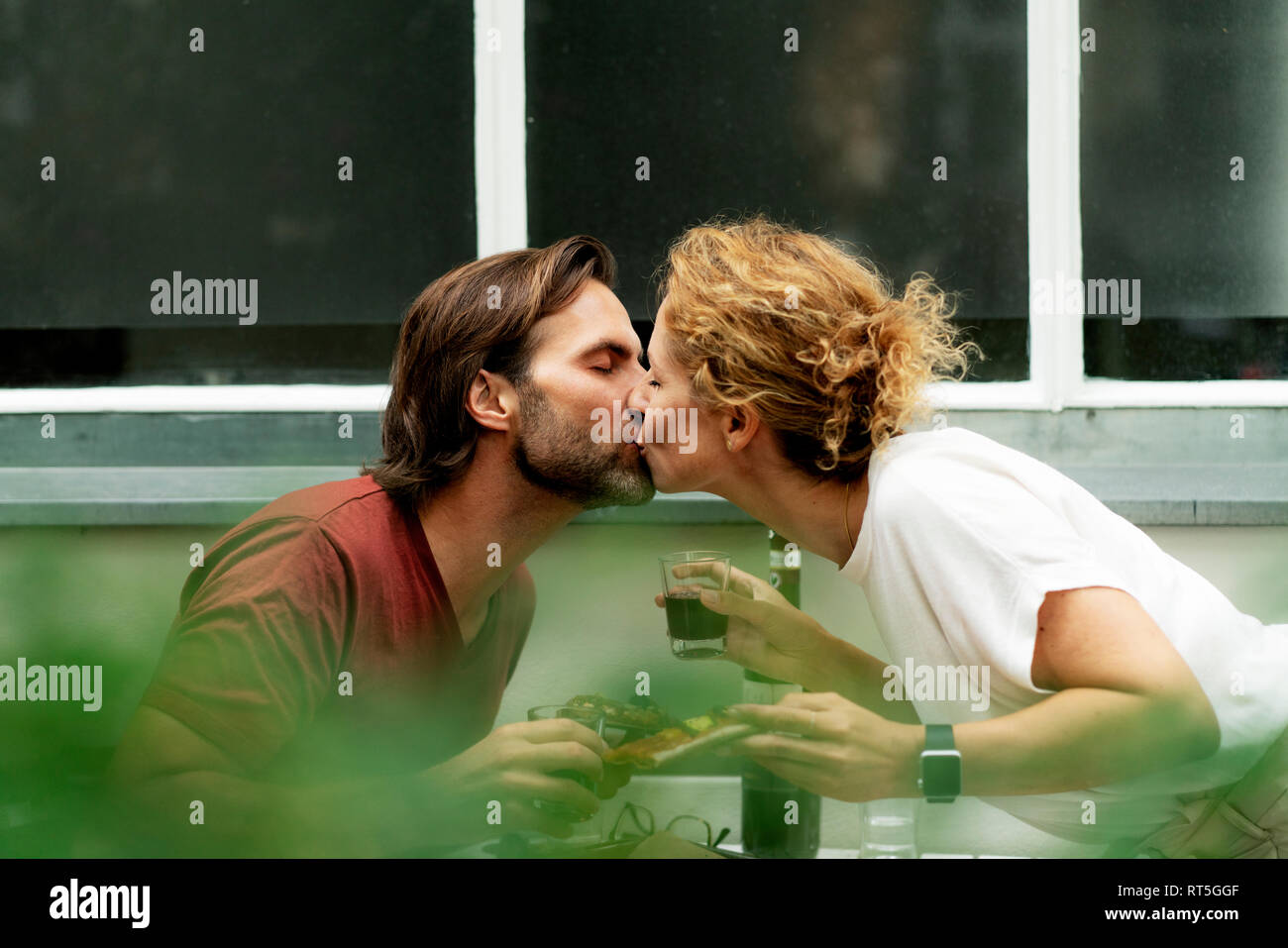 Happy couple kissing at the table, eating pizza, drinking wine Stock ...