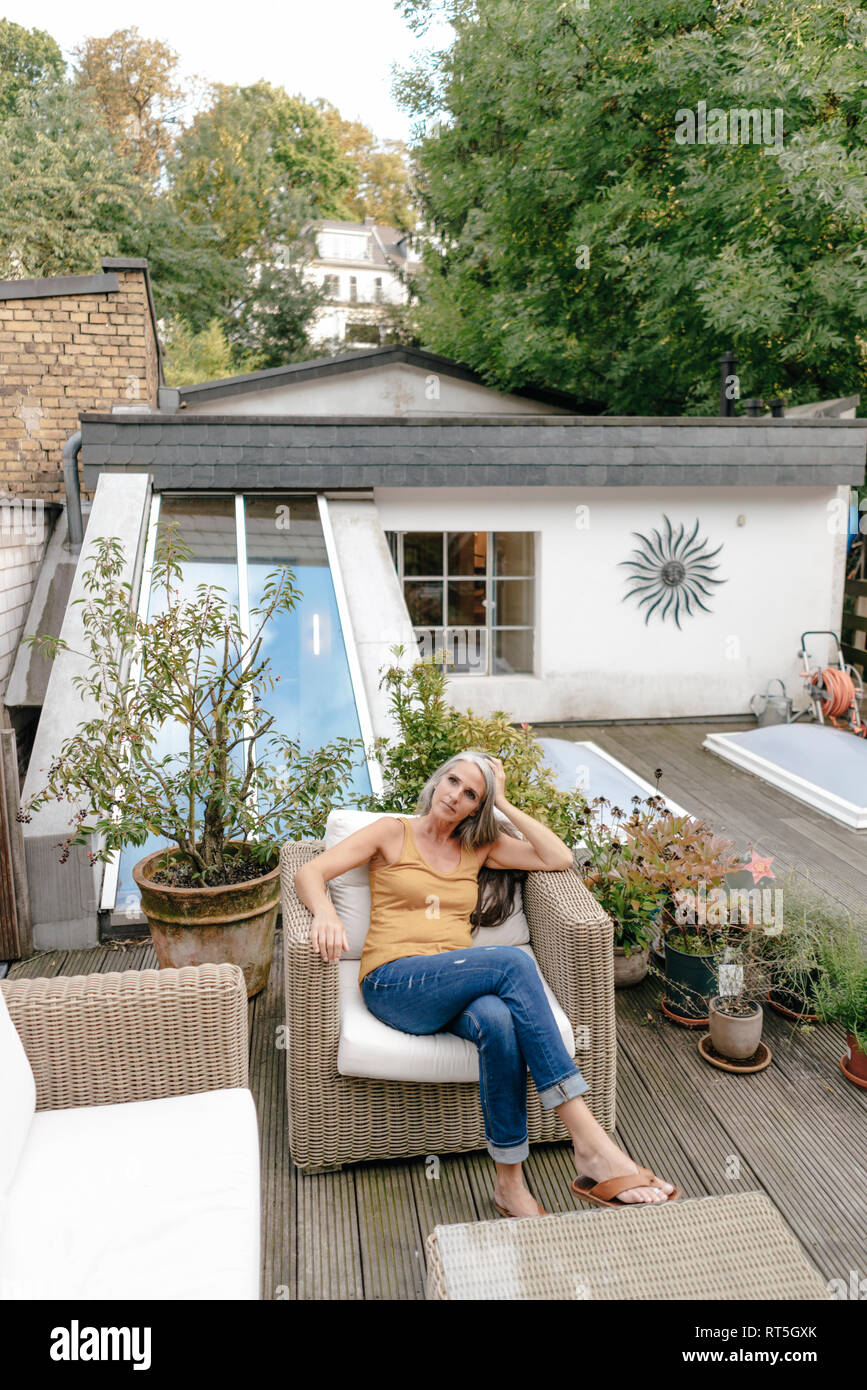 Woman relaxing on terrace Stock Photo - Alamy