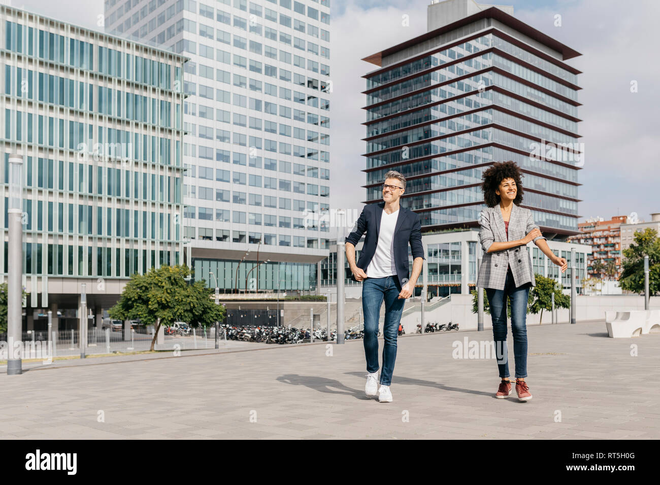 Two happy colleagues walking outside office building Stock Photo - Alamy