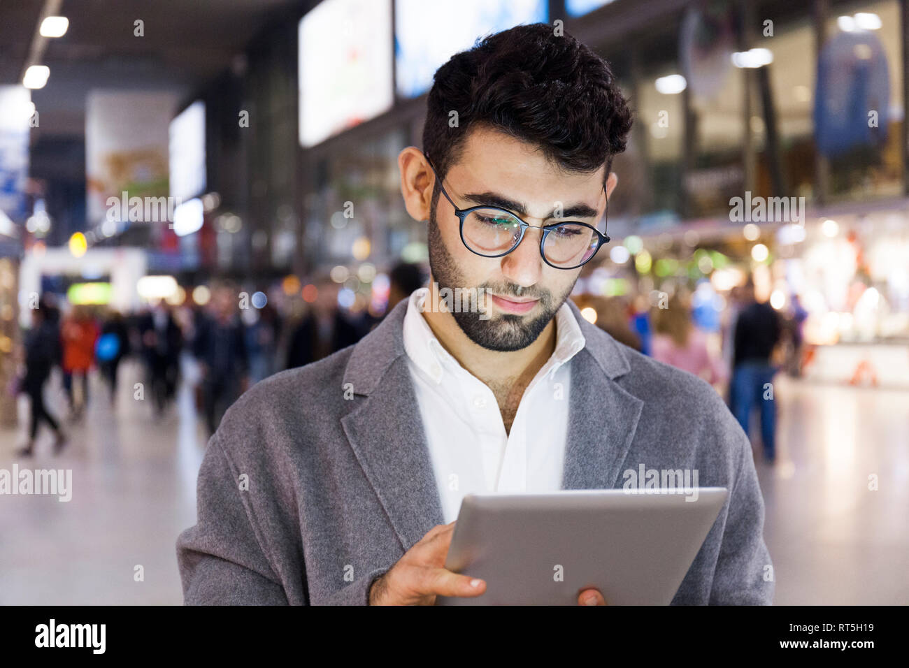 Germany, Munich, portrait of young businessman using digital tablet at ...