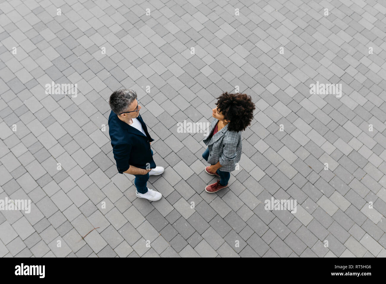 Top view of two colleagues talking on a square Stock Photo - Alamy