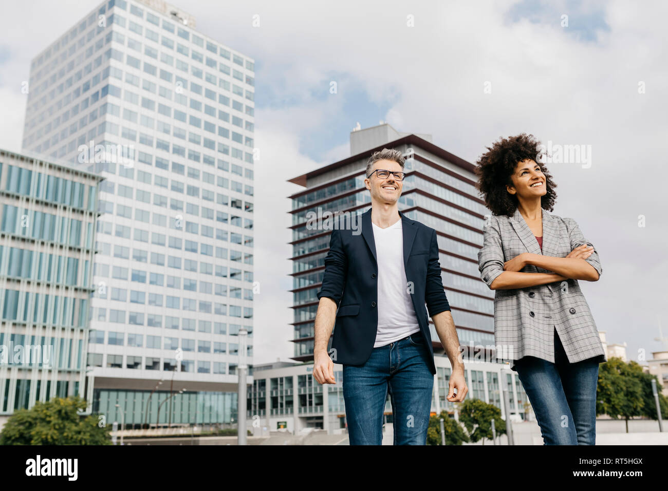 Two happy colleagues walking outside office building Stock Photo - Alamy