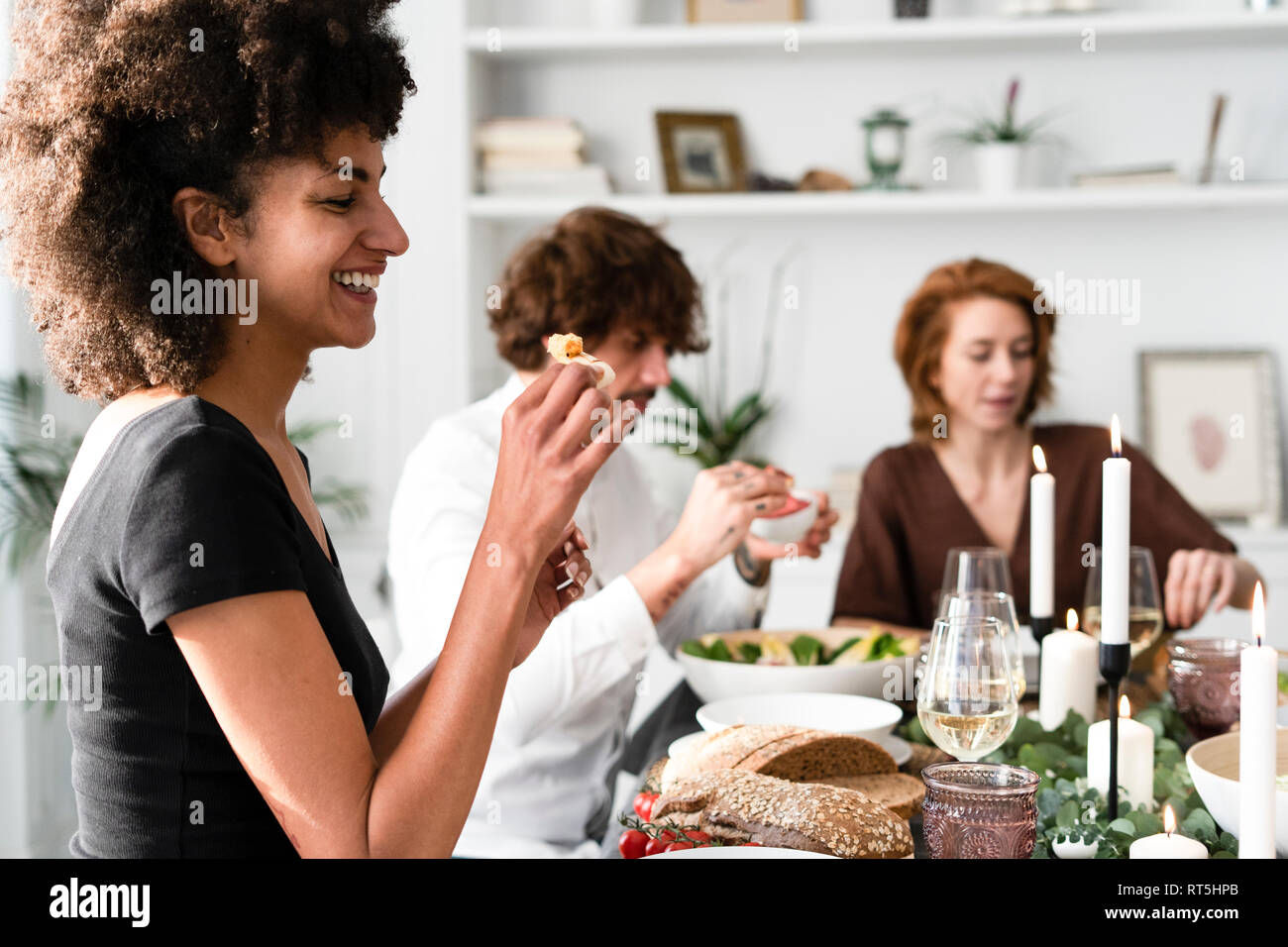 Friends having fun at a dinner party, enjoying eating together Stock ...