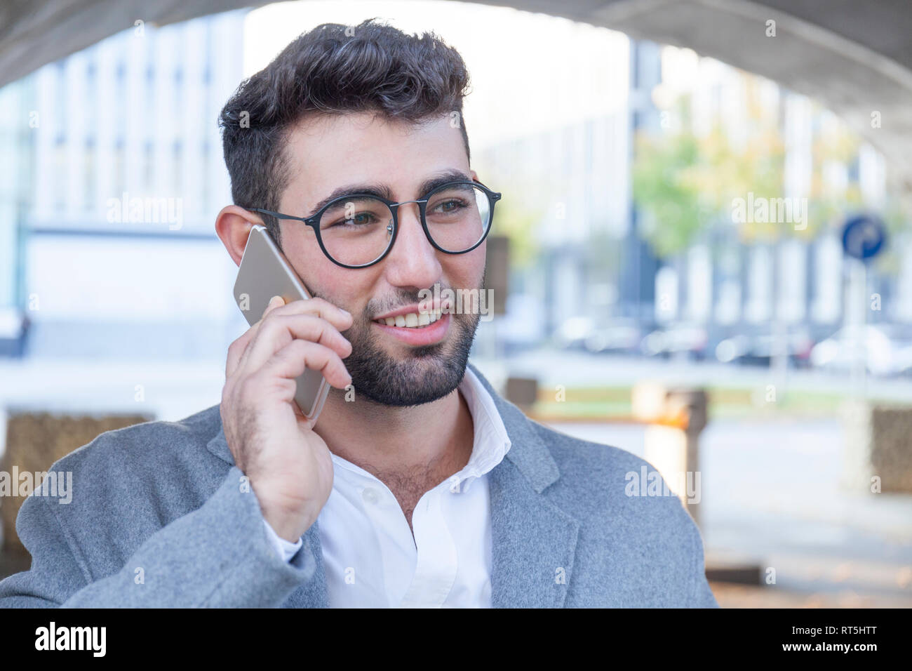 Portrait of smiling young businessman on the phone Stock Photo - Alamy