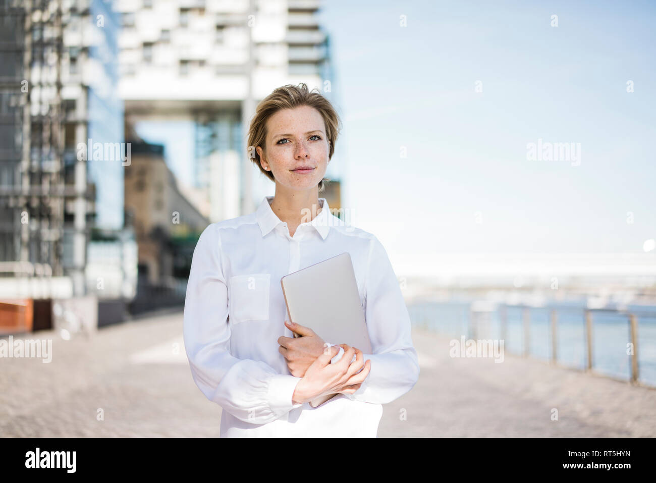 Young woman carrying laptop, portrait Stock Photo - Alamy
