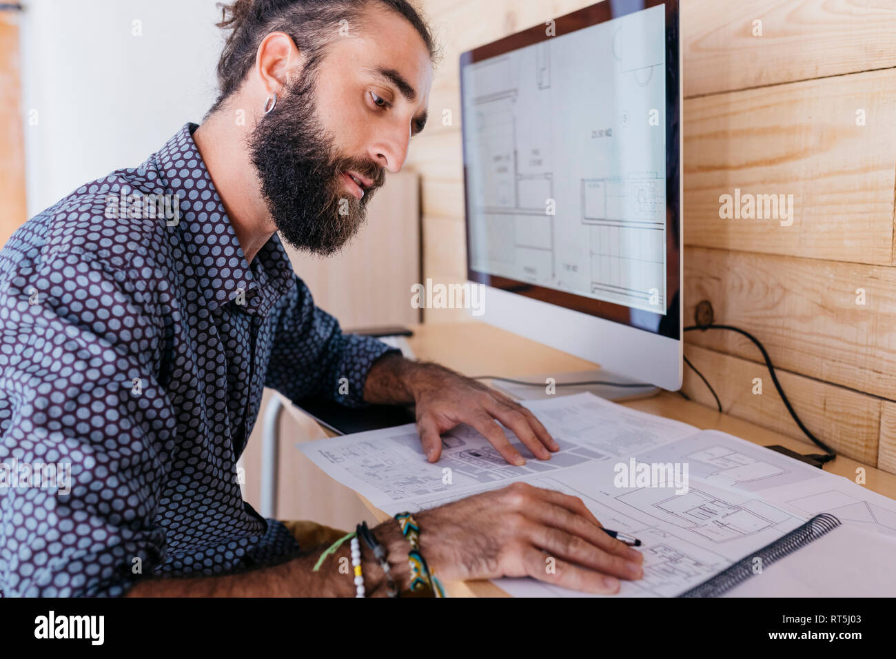 Young architect working at home with blueprints and computer Stock ...