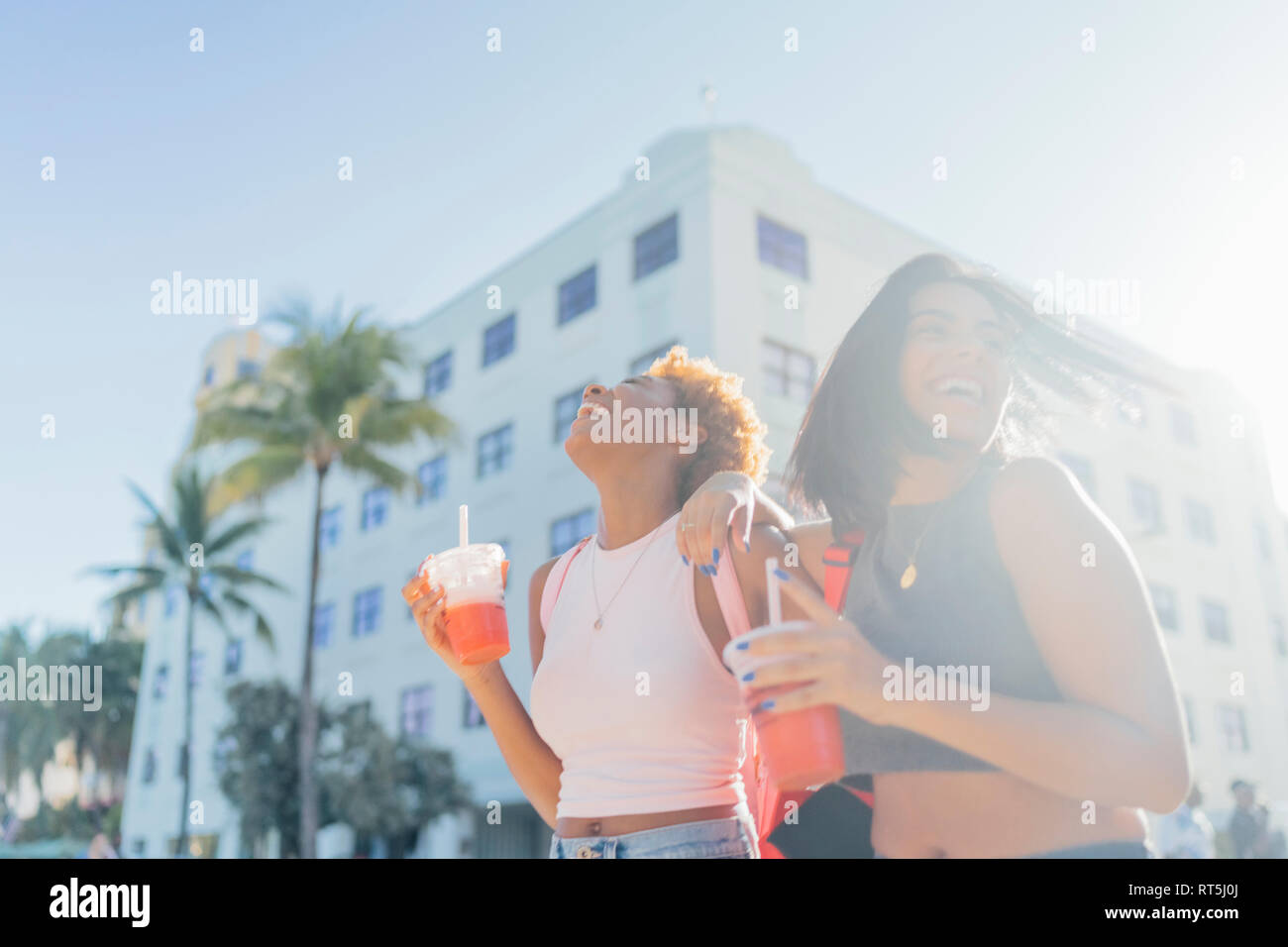 USA, Florida, Miami Beach, two happy female friends having a soft drink ...