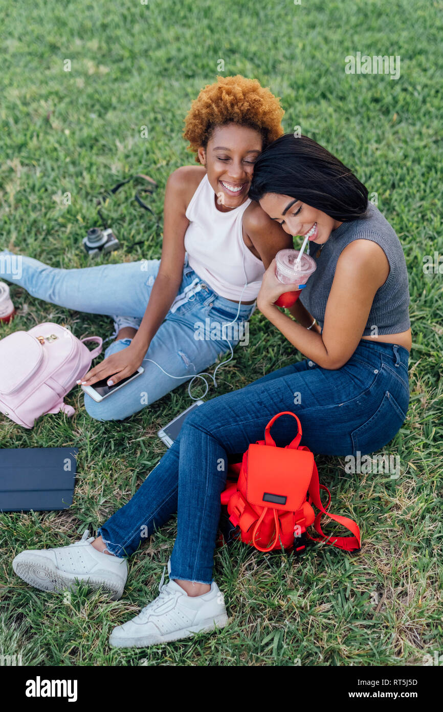 Two happy female friends relaxing in a park Stock Photo - Alamy