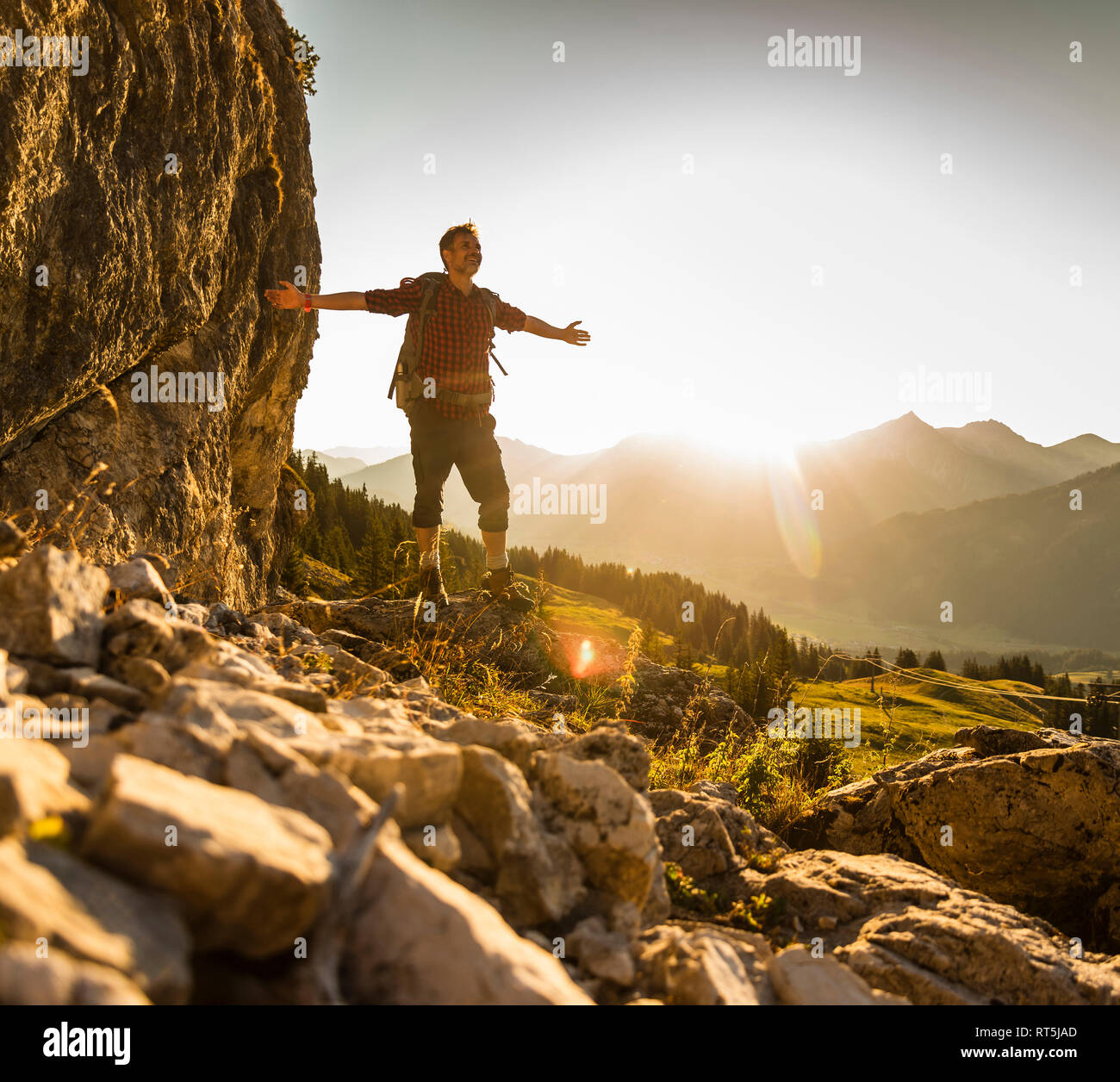 Hiking man standing in he mountains, cheering Stock Photo - Alamy