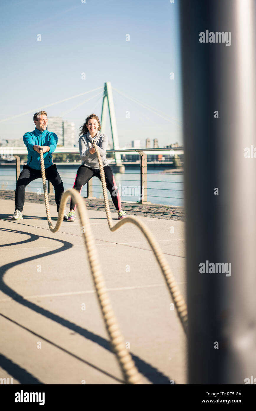 Friends training at the riverside, pulling rope Stock Photo - Alamy