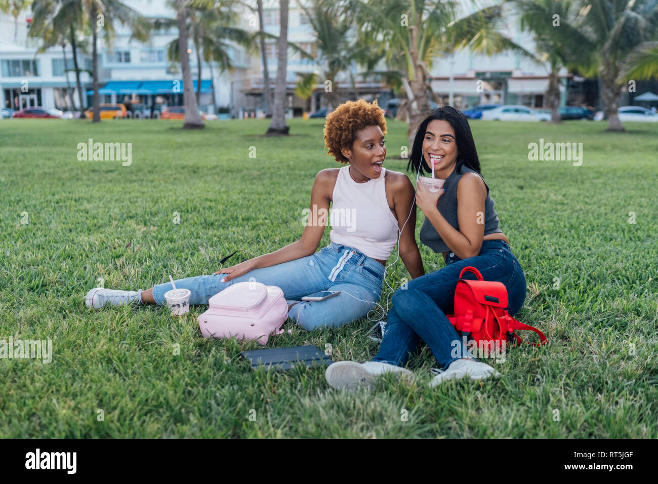 Two happy female friends relaxing in a park Stock Photo - Alamy
