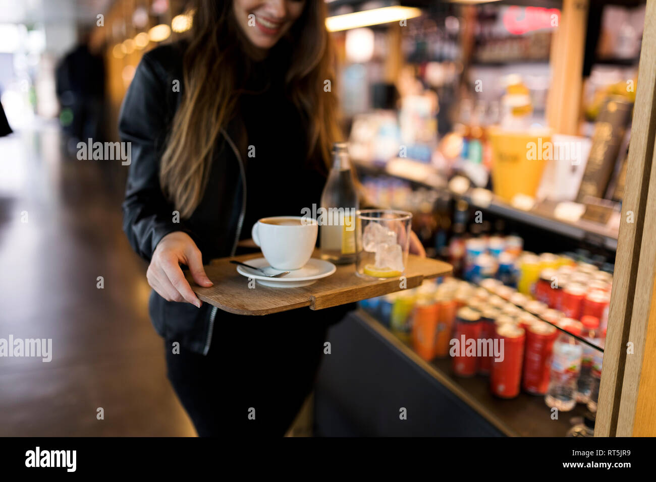 Close-up of woman carrying tray with coffee and soft drink in a self ...