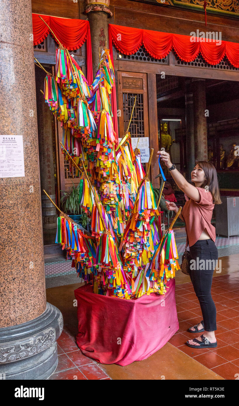 Young Woman Hanging a Wishing Ribbon on the Wishing Tree, Kek Lok Si ...