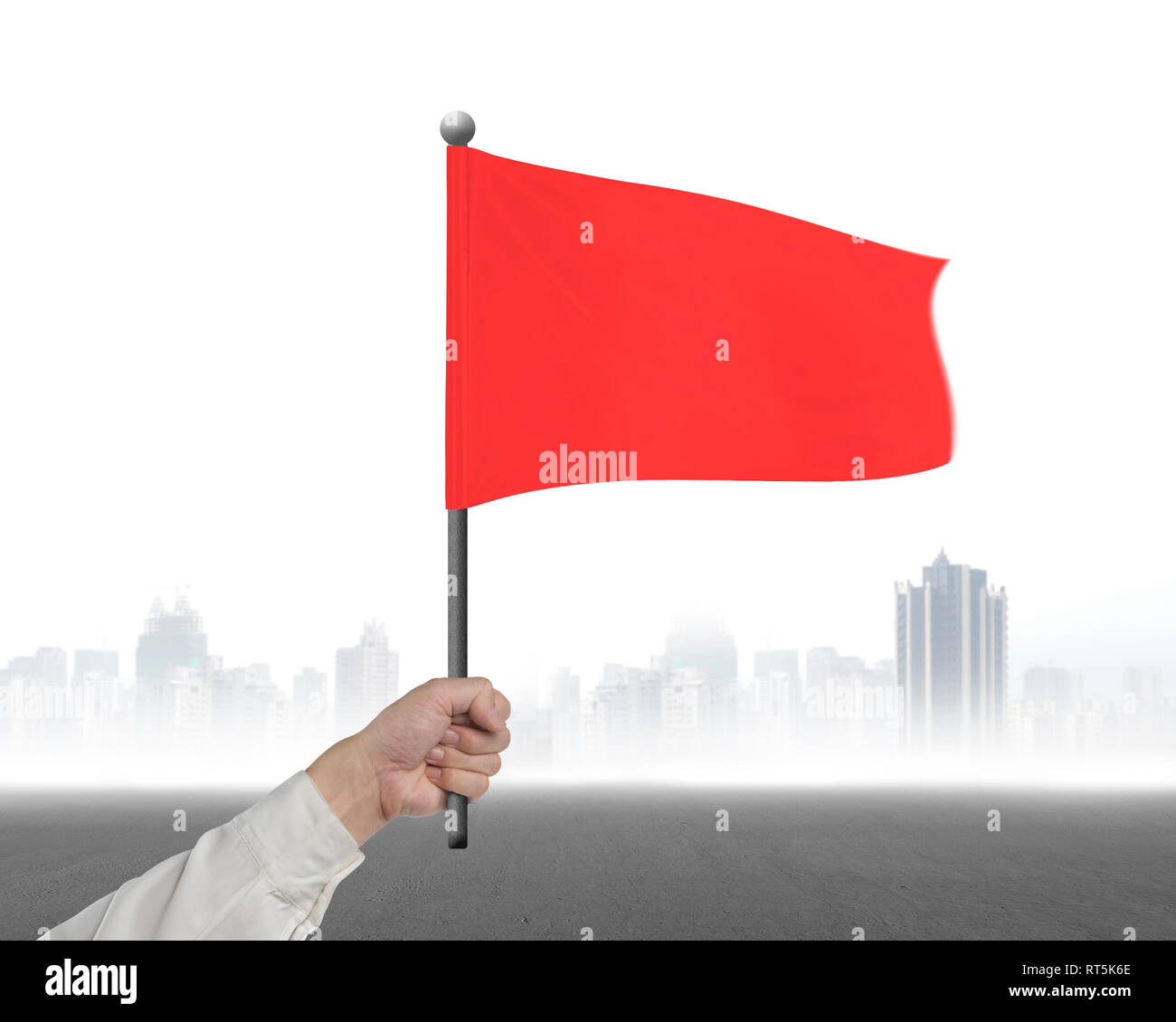 Hand holding wavy red flag with mist city background Stock Photo - Alamy
