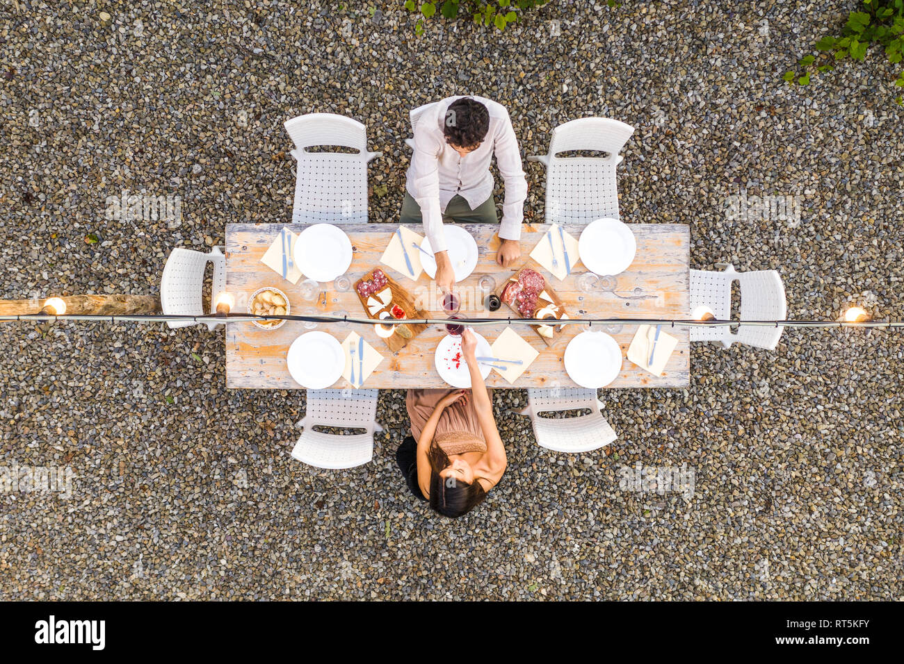 Top young couple dining al fresco clinking red wine glasses hi-res ...