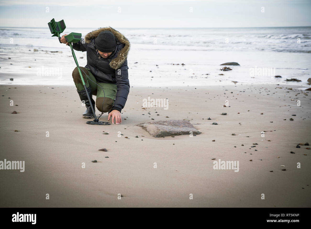 Man with metal detector at the sand beach Stock Photo - Alamy