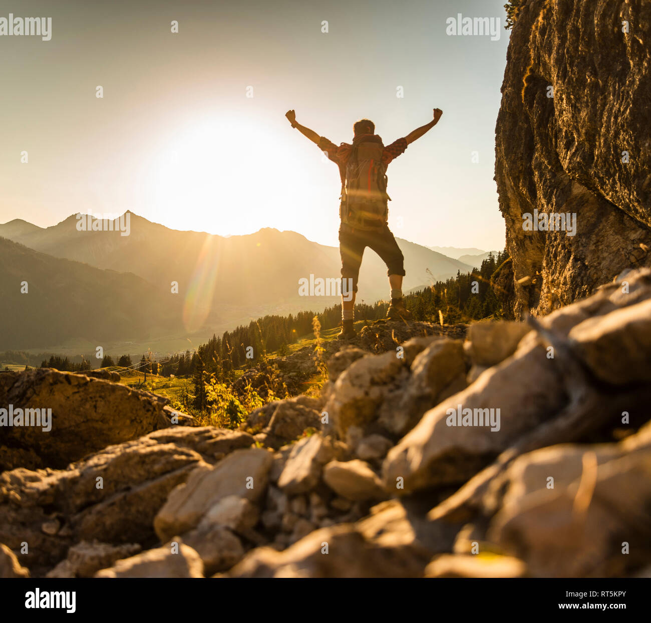 Hiking man standing in he mountains, cheering Stock Photo - Alamy
