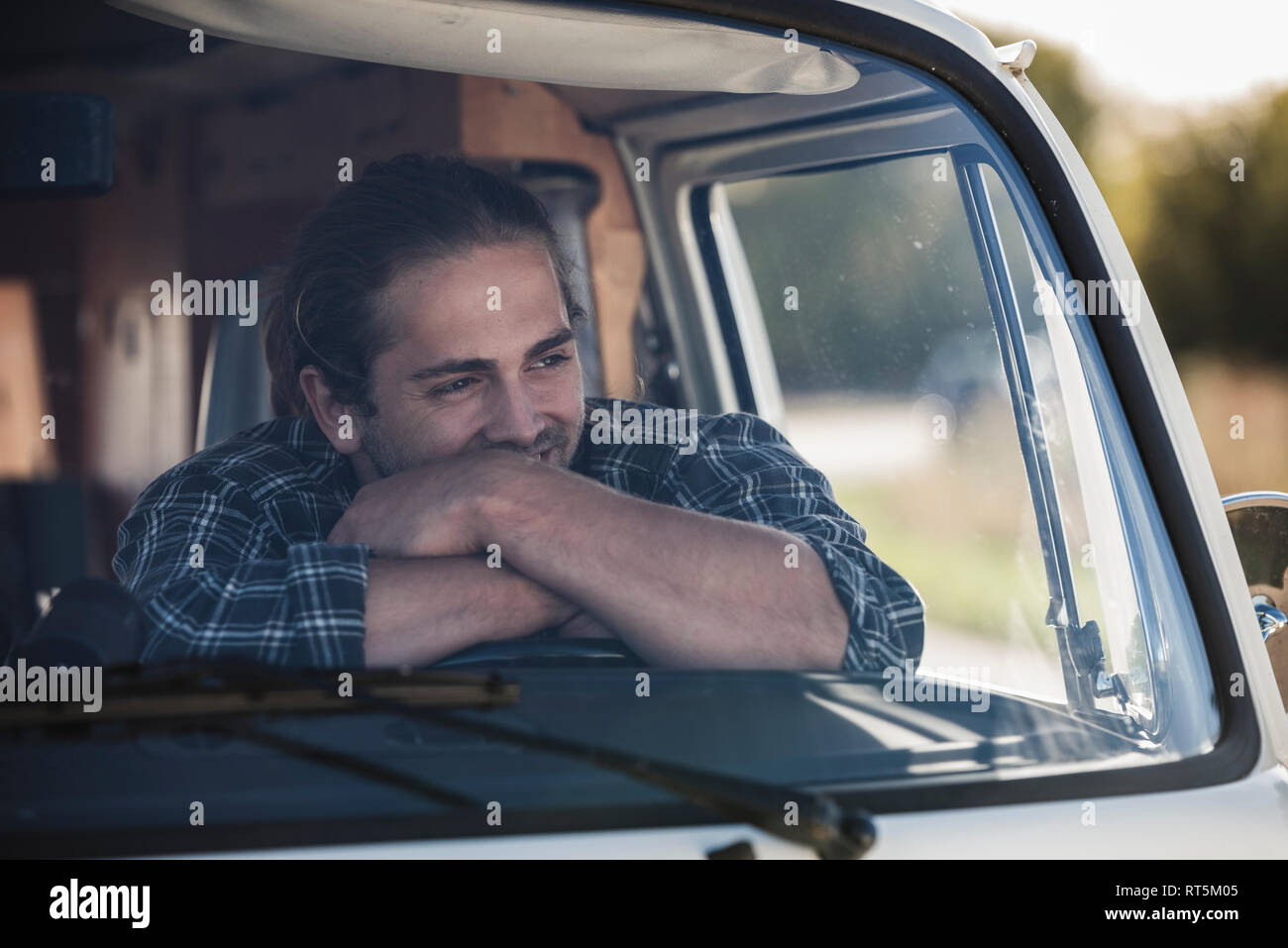 Young man on a road trip with his camper, taking a break, relaxing ...